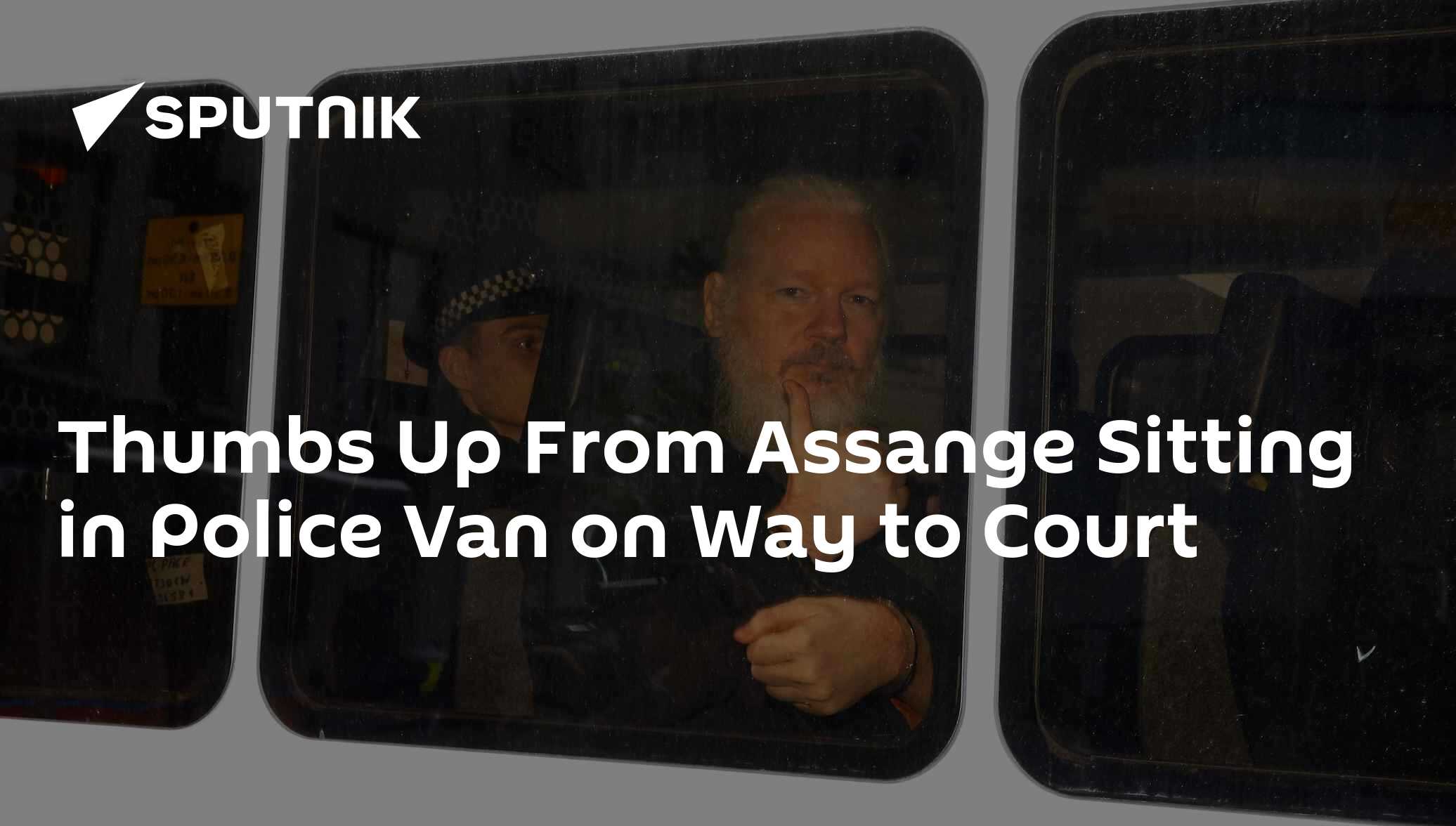 Thumbs Up From Assange Sitting in Police Van on Way to Court - 11.04. ...